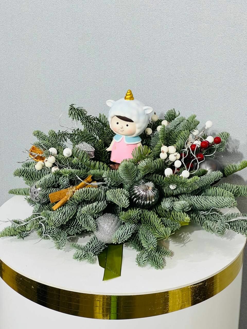 Новогодняя композиция из ели с сувениром "Девочка в шапке и розовом платье" живая елка, нобилис