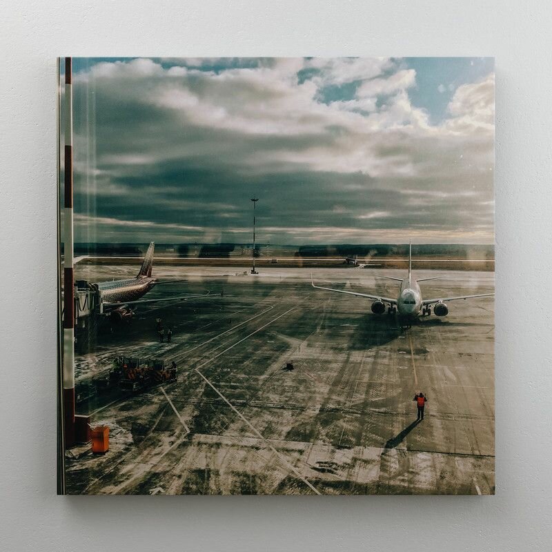 Интерьерная картина на холсте "Человек, стоящий на перроне аэропорта рядом с самолетом" размер 60x60 см