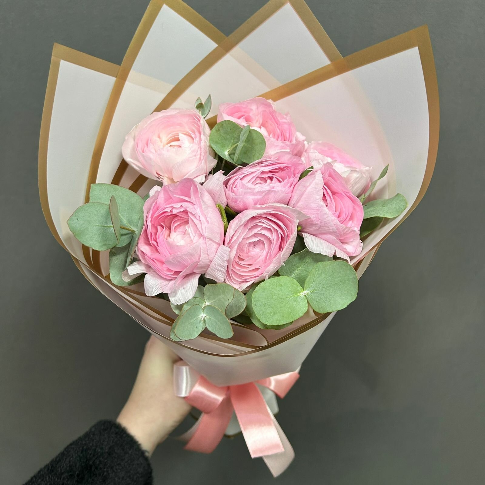 Монобукет из 7 розовых ранункулюсов и эвкалипта в дизайнерской пленке