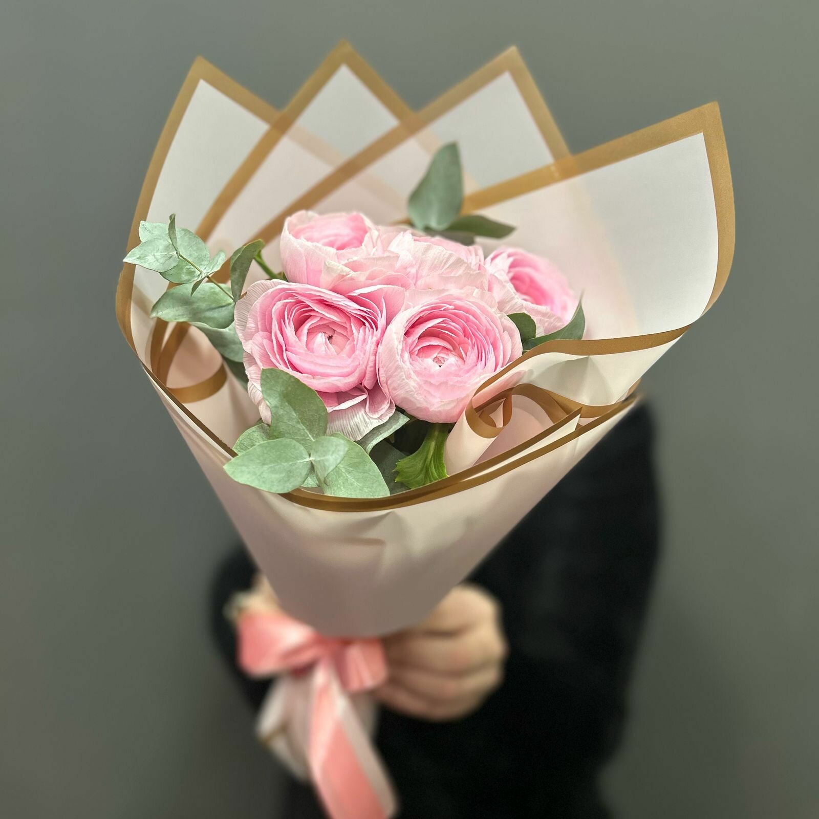 Букет из 5 розовых ранункулюсов и эвкалипта в дизайнерской пленке