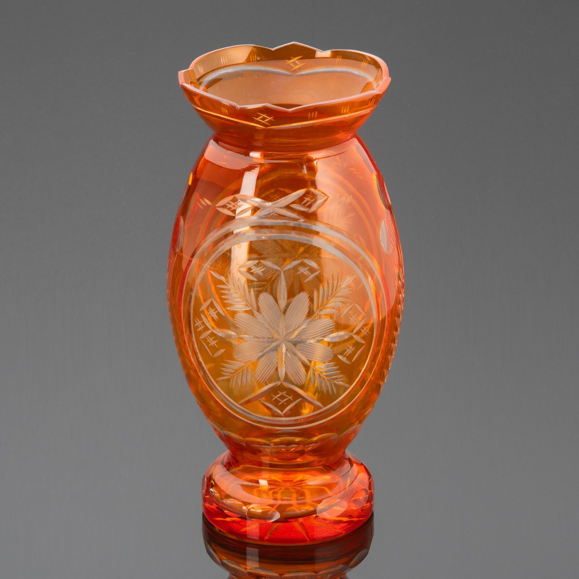 Ваза оранжевого цвета, украшенная цветочным декором