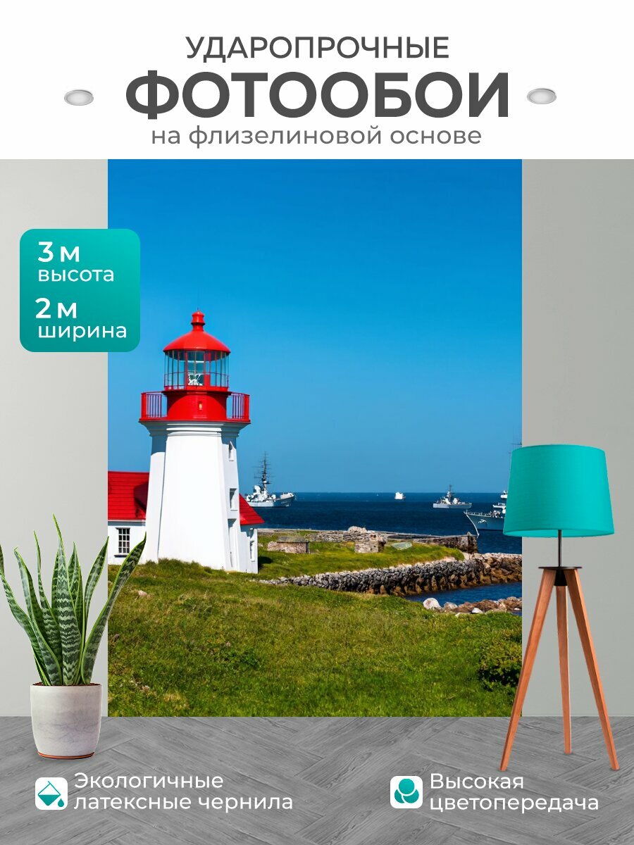 Фотообои моющиеся ударопрочные "Маяк на берегу уютного рыбацкого села, с красной крышей и белыми стенами, окружающий его зеленый луг и военные корабли" 200x300 см. флизелиновые на стену