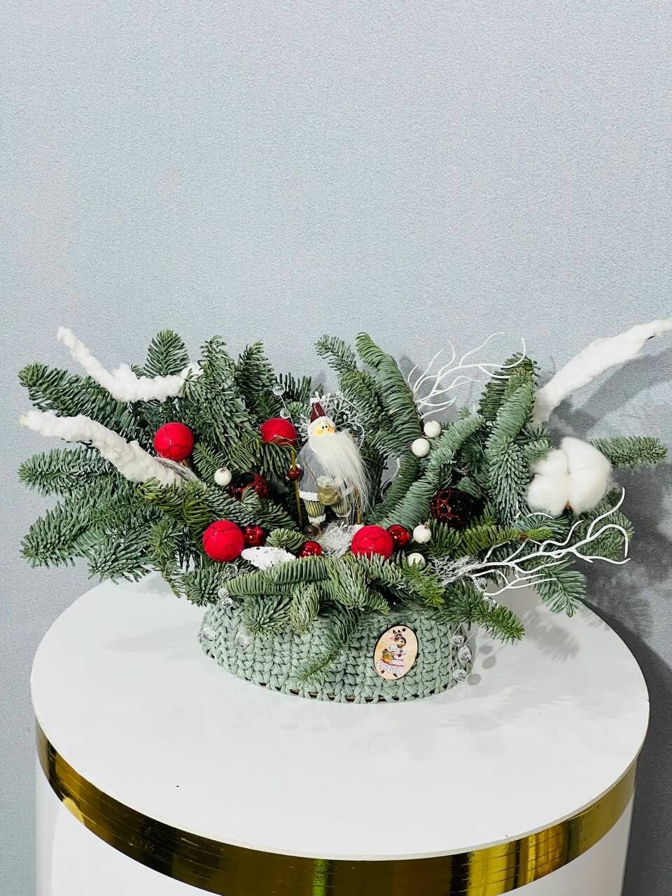Хвойный букет на стол из натурального нобилиса в вязаном кашпо с сувениром Дед Мороз