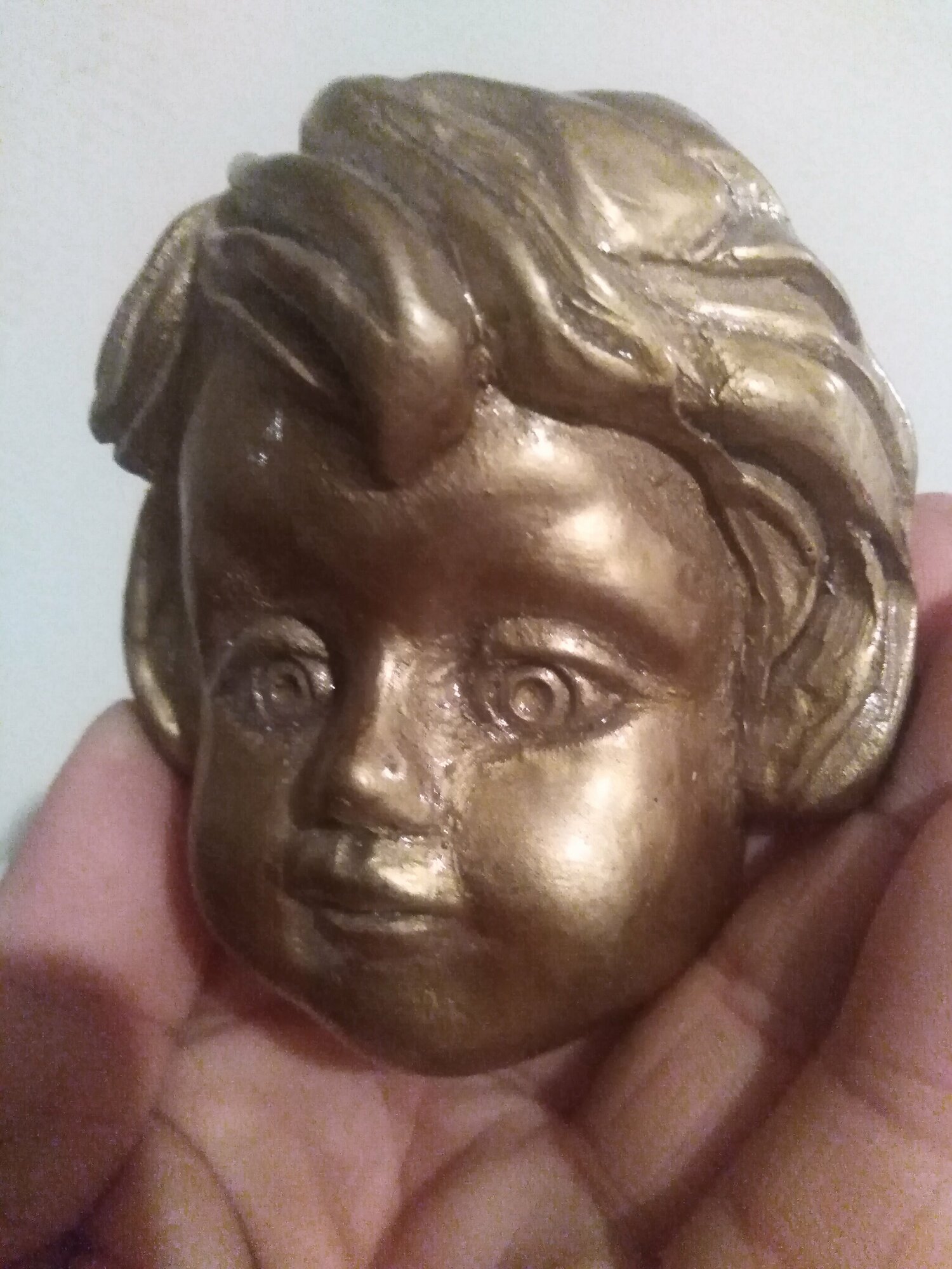 Барельеф головки путти