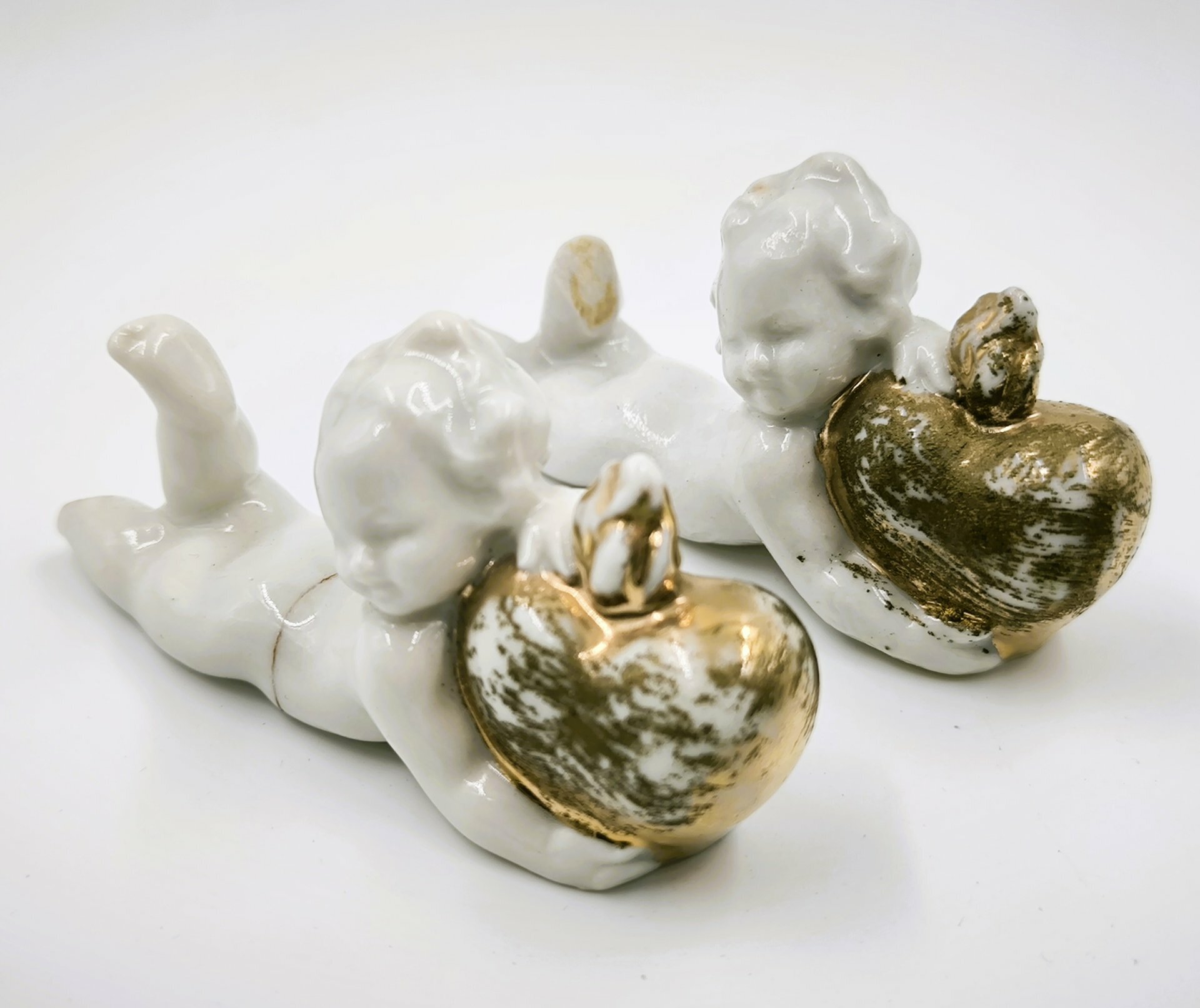 Статуэтки парные в виде лежащих путти с сердцами, фарфор, золочение, Германия