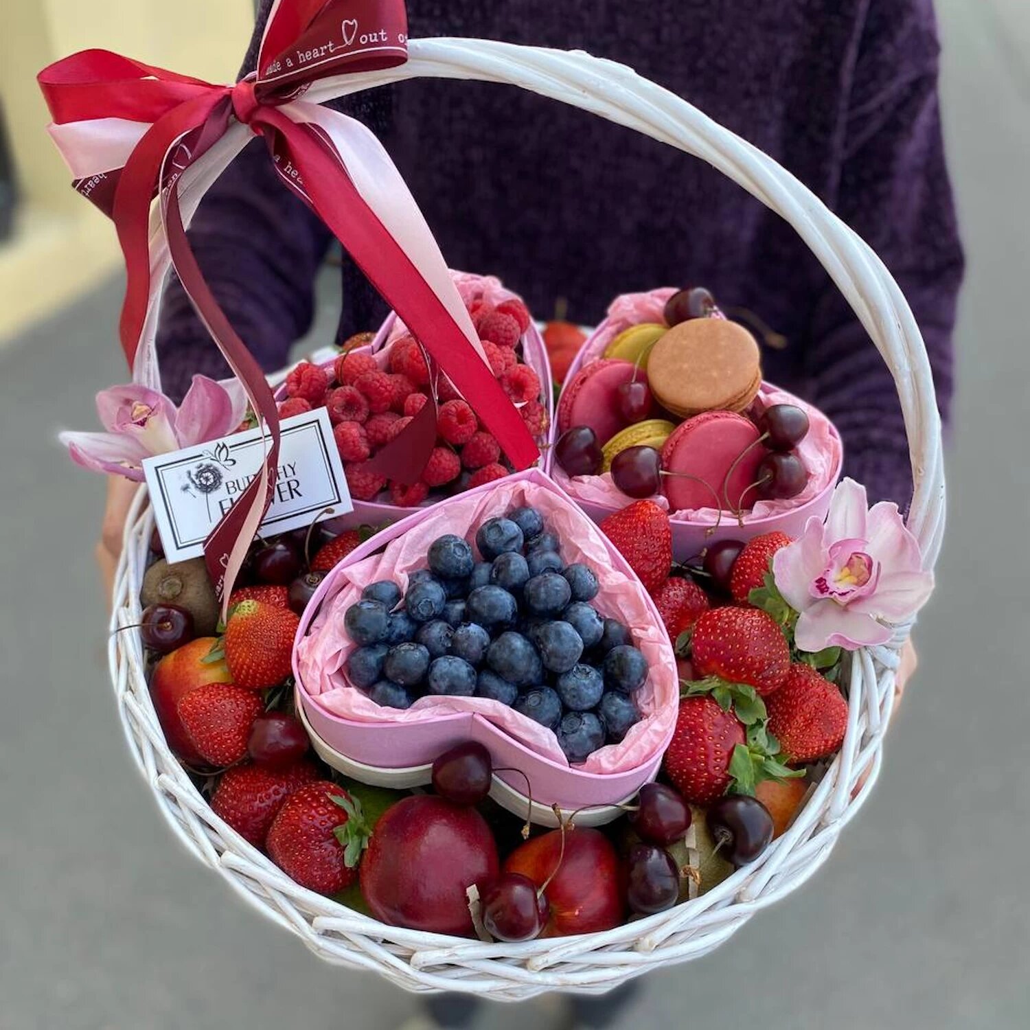 Подарочная корзина с фруктами, ягодами, пирожными малиной ежевикой и розами