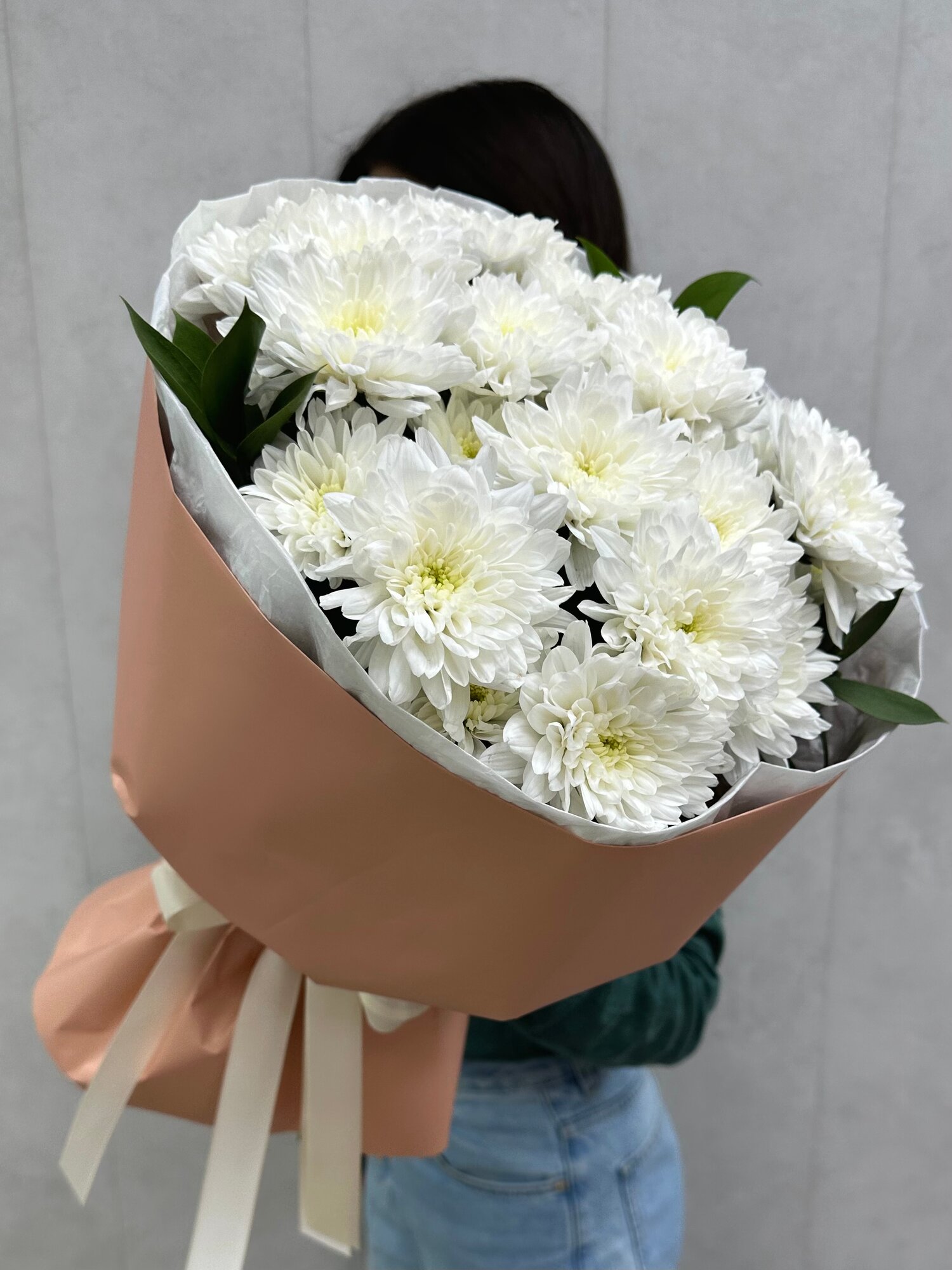 Букет из трёх белых кустовых хризантем и рускуса в бежевой упаковке
