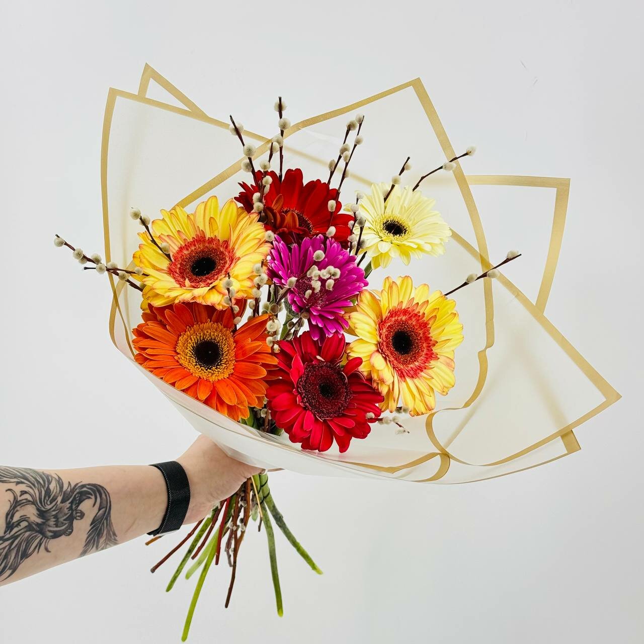 Букет из 7 ярких гербер с веточками живой вербы. Герберы в дизайнерской упаковке. Пасхальный букет