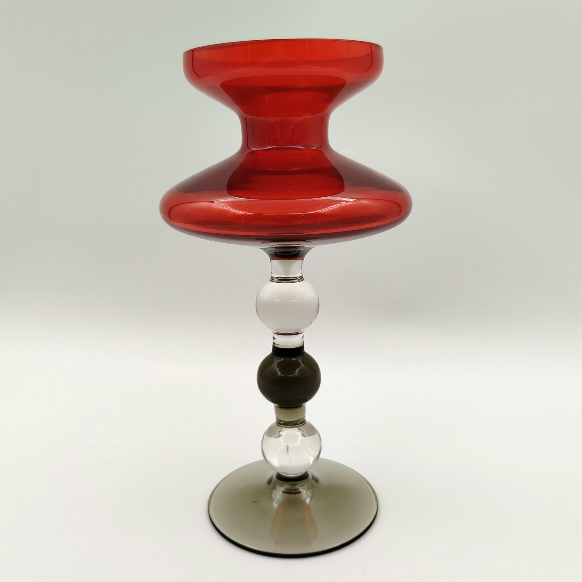 Подсвечник красного цвета на фигурной ножке, выполненный в скандинавском стиле