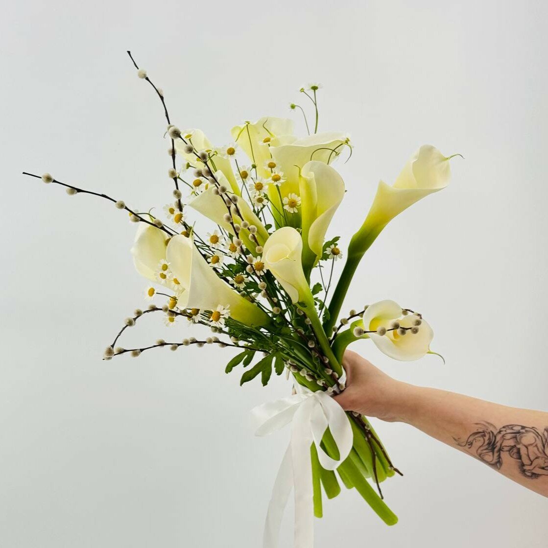 Белые каллы с полевыми ромашками танацетум матрикария с веточками живой вербы