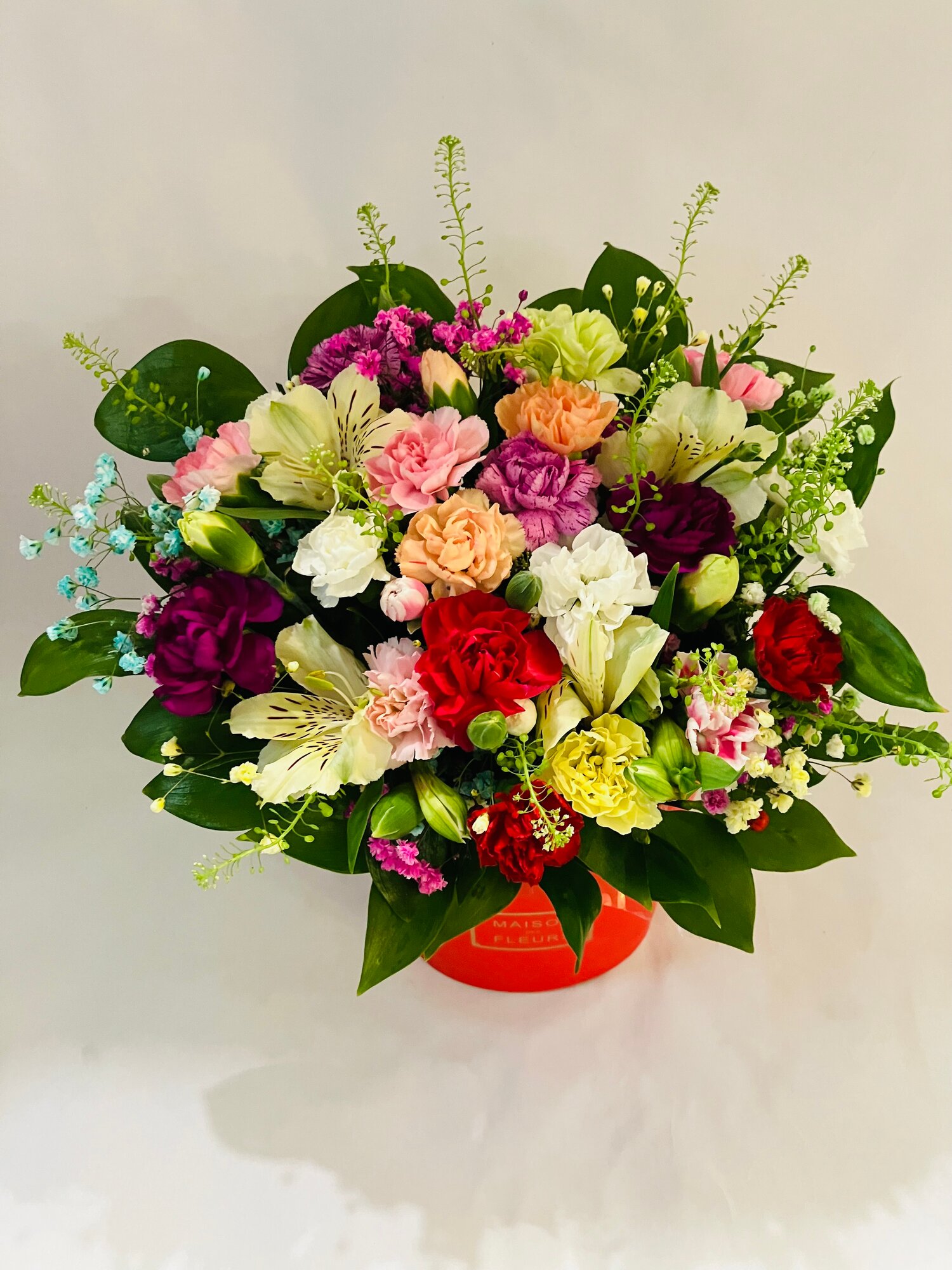 Букет Композиция из кустовых гвоздик, гринбелла, белой альстромерии в красной коробке