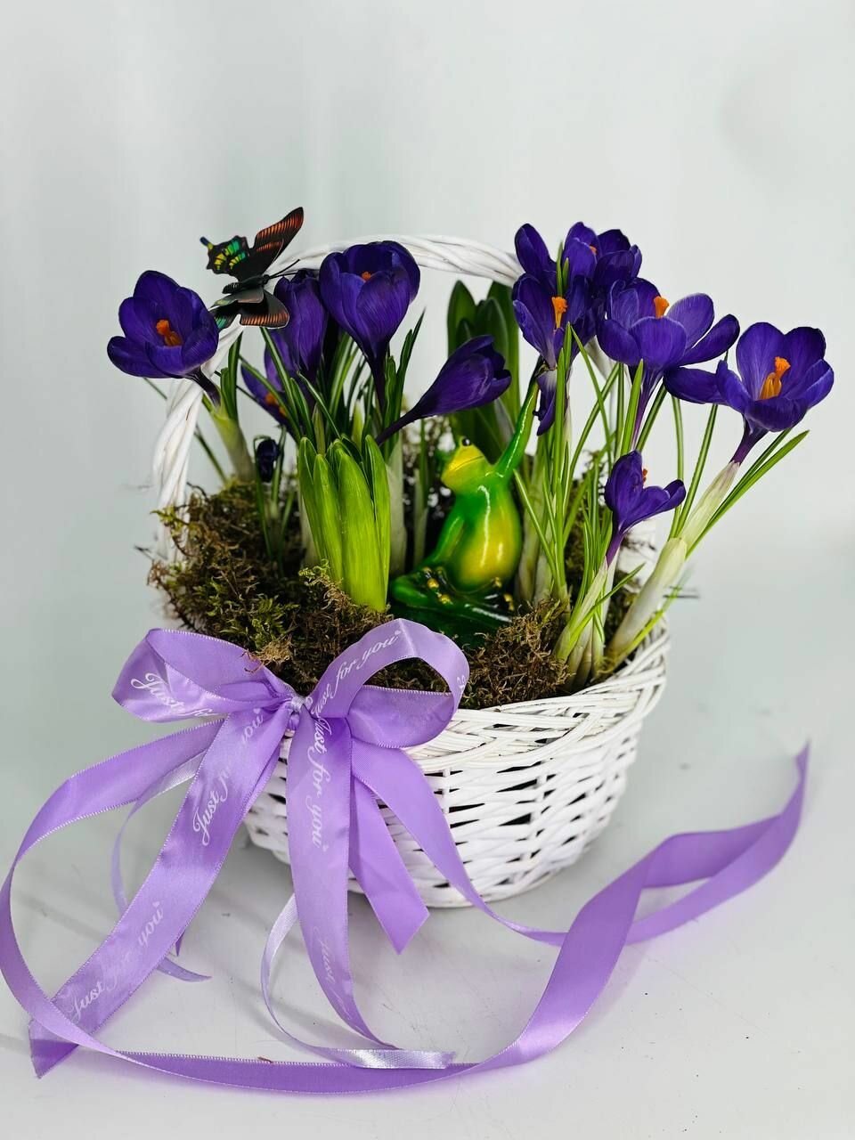 Композиция из первоцветов: крокусы, гиацинты в корзине с лягушонком