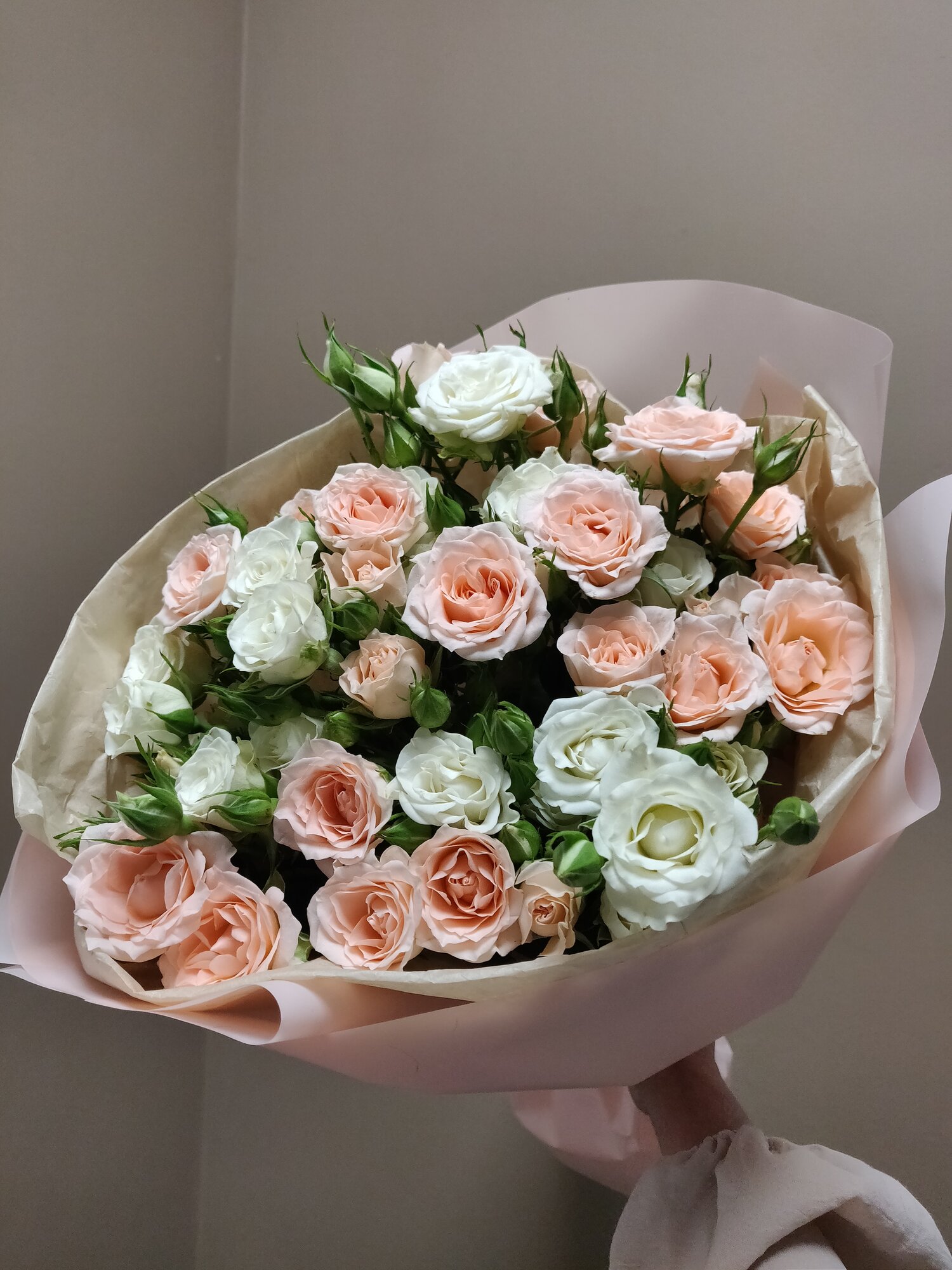 Нежный, объемный букет кустовых белых и розовых роз в эффектной упаковке.