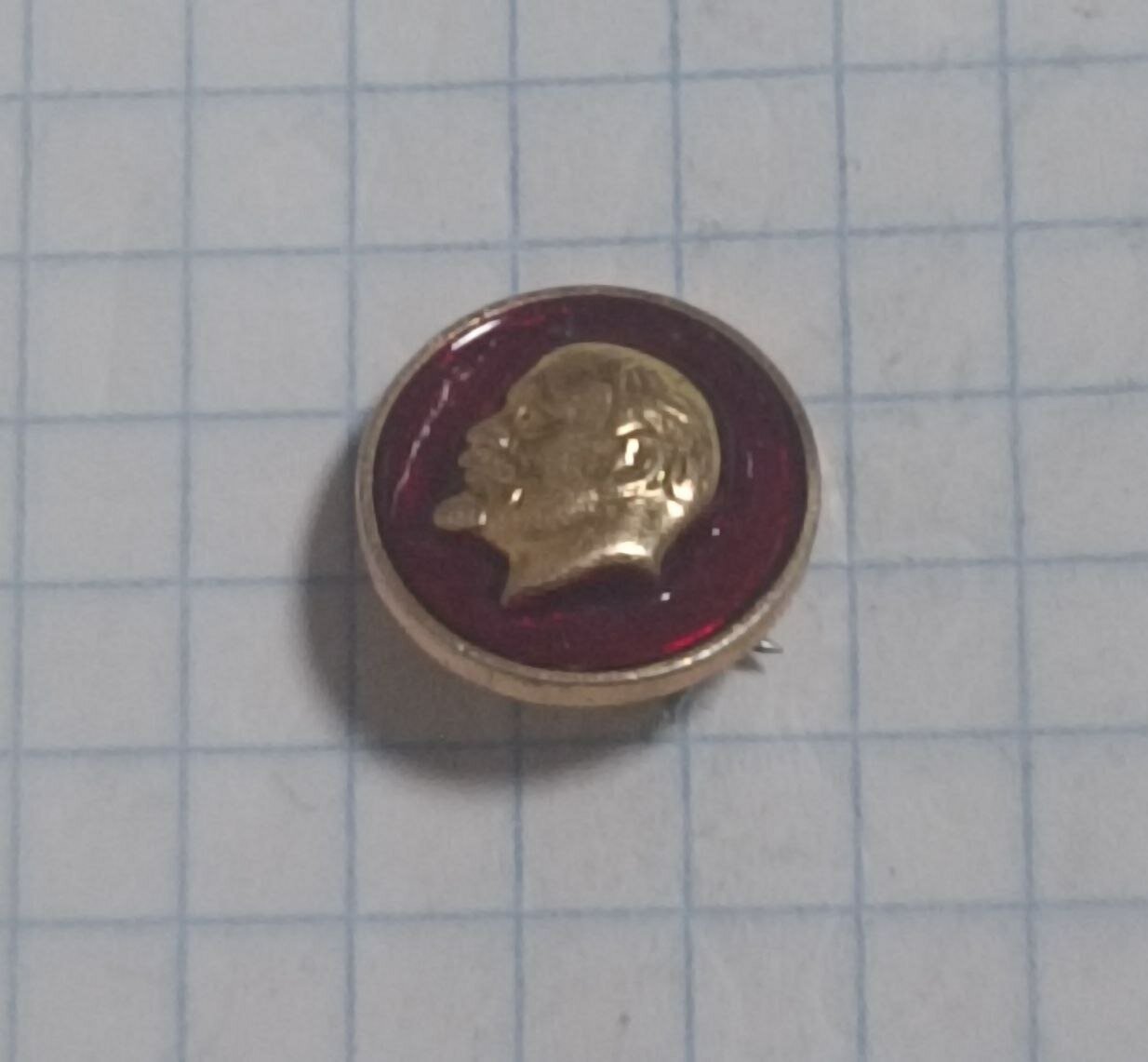 Значок с профилем Ленина на красном фоне