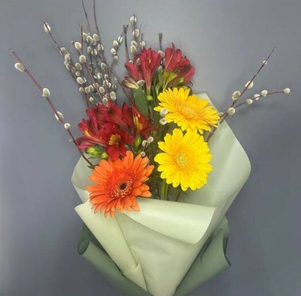 Яркий букет из гербер и альстромерий с веточками живой натуральной вербы. Пасхальный букет