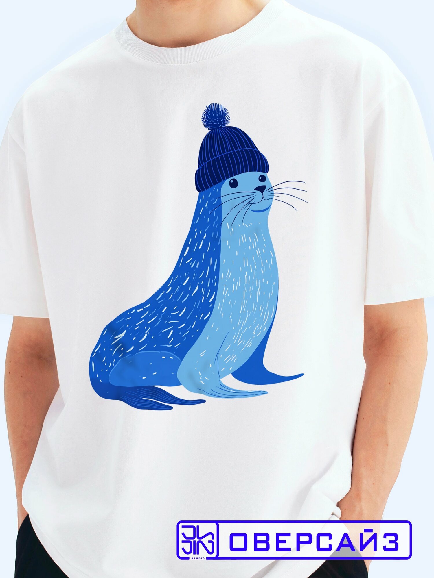 Футболка оверсайз мужская с принтом Смешной веселый тюлень в темно синей, теплой шапке и синем образе с животными, белый хлопковый трикотаж с прикольным рисунком на груди