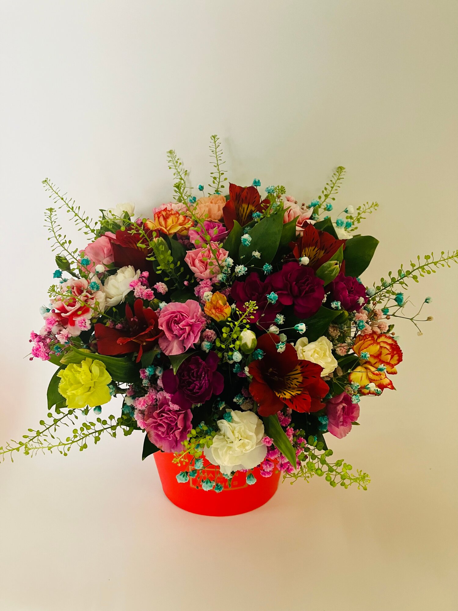 Букет Композиция из кустовых гвоздик, красной альстромерии, гринбелла в красной коробке