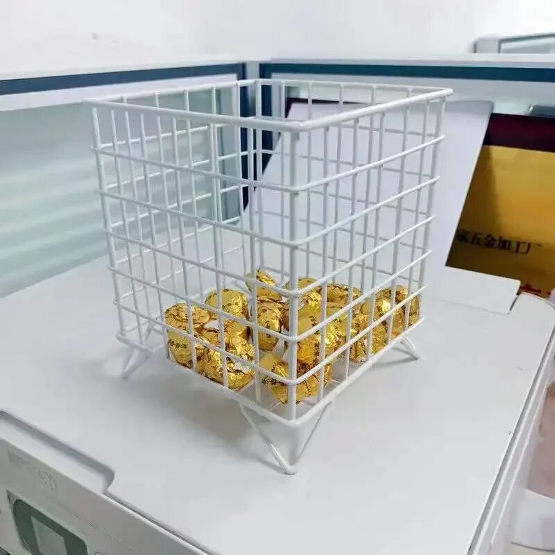 Белая металлическая корзина для хранения с золотыми конфетами