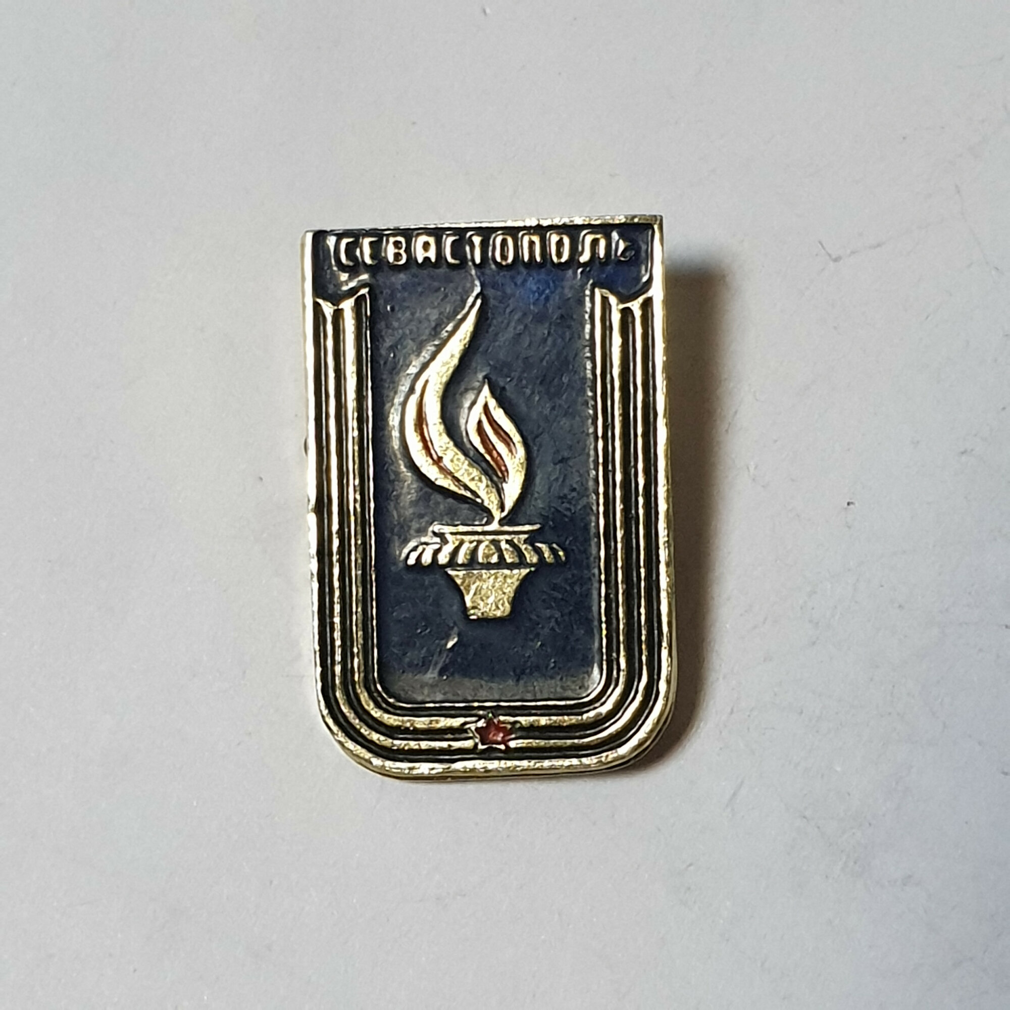 Значок СССР. Севастополь. Вечный огонь на фоне черной эмали. Советский и винтажный.