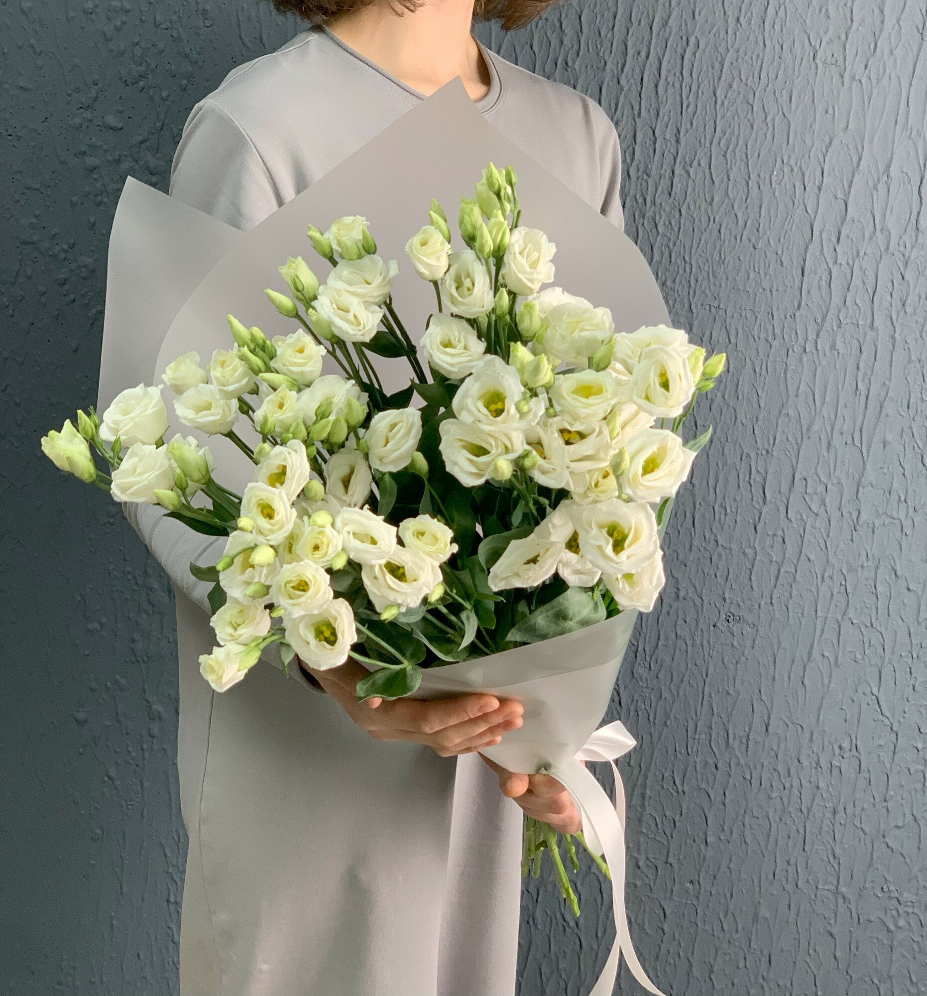 Букет живых цветов из 7 стеблей Эустомы в дизайнерской упаковки под атласную ленту.