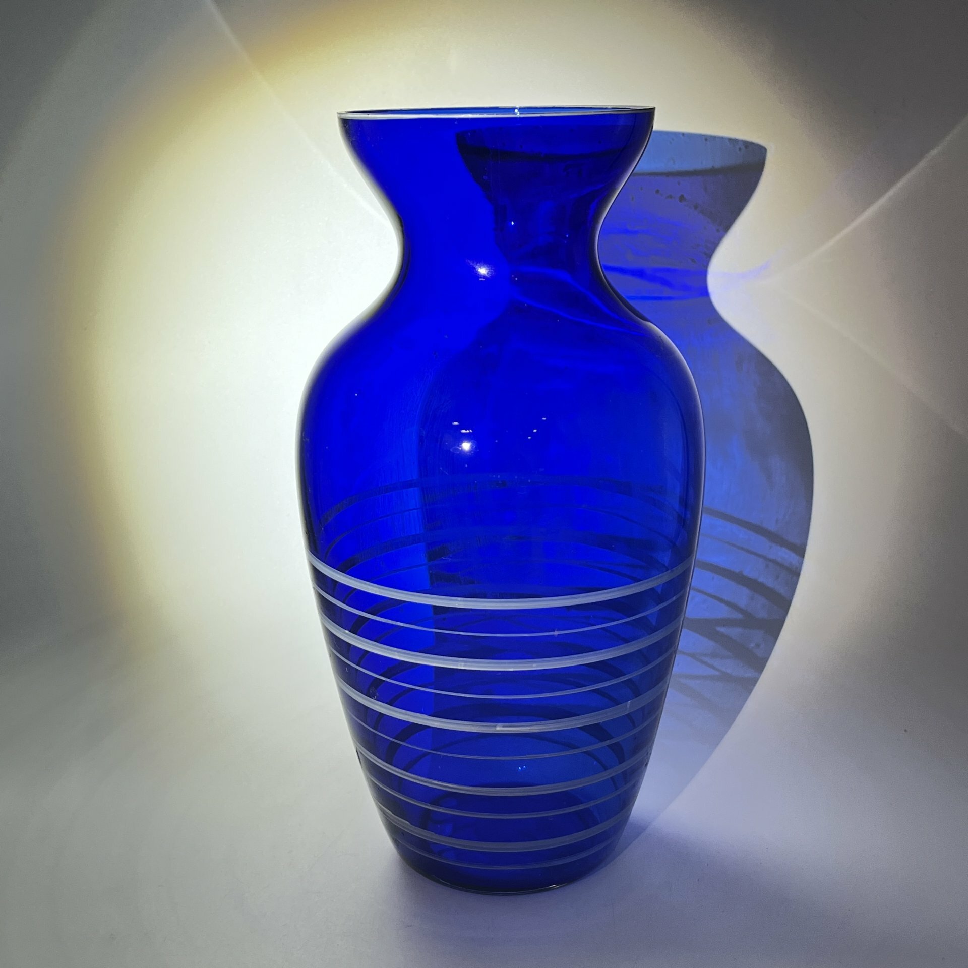 Ваза кобальтового оттенка, украшенная полосатым декором, цветное стекло