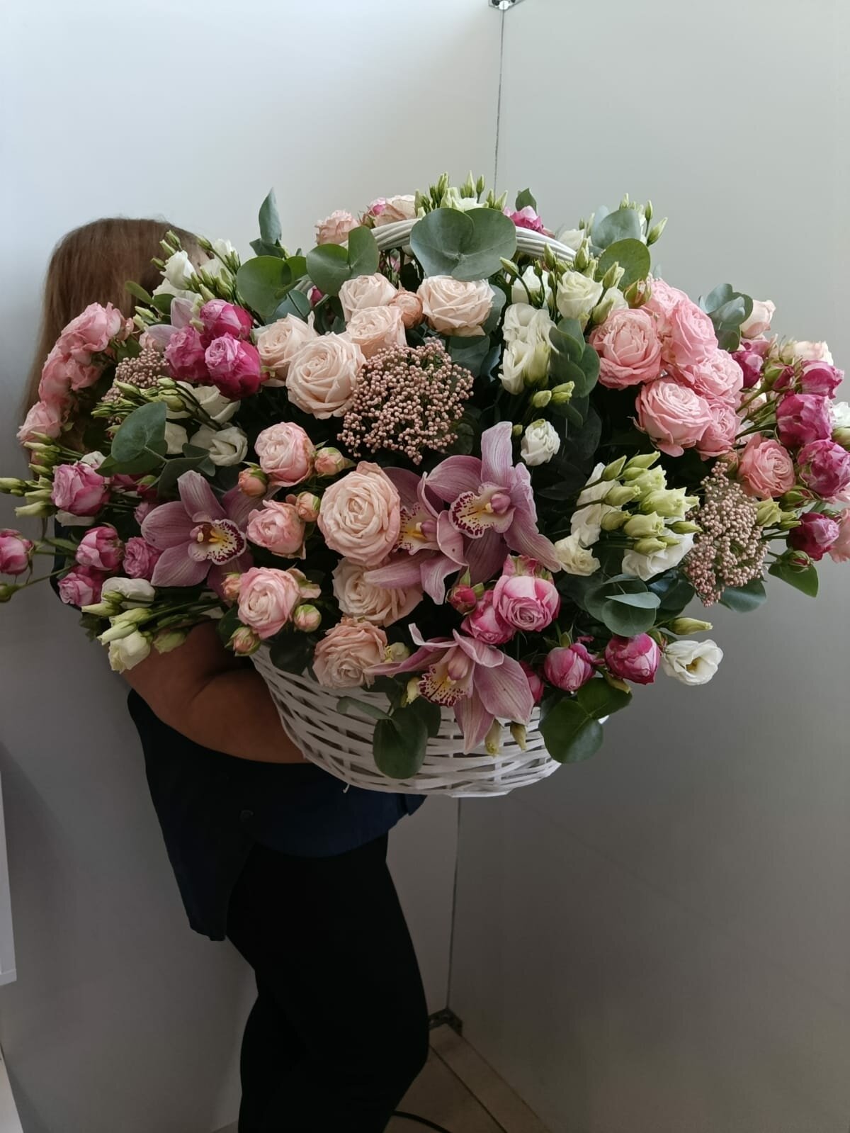 Букет цветов в корзине, с орхидеями, розами кустовыми пионовидными, эустомами и эвкалиптом, озотамнусом