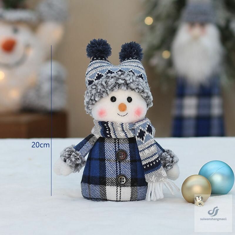 Красивая и милая вязаная игрушка-снеговик под рождественской елкой