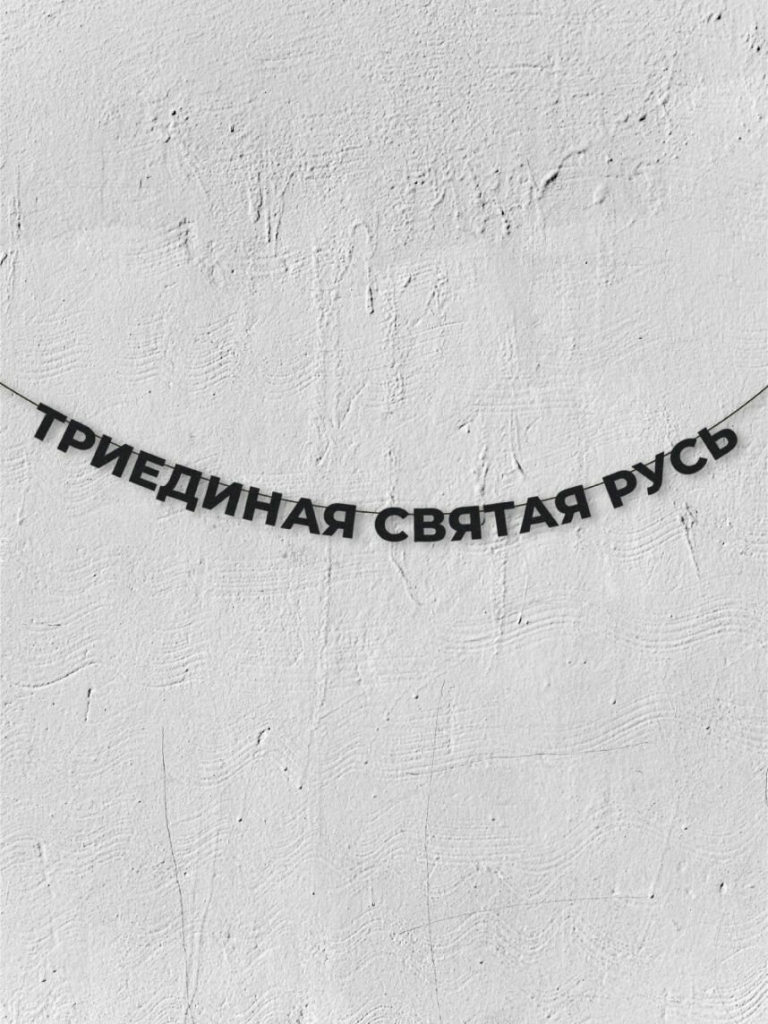 Бумажная гирлянда из чёрных букв «Триединая святая Русь»