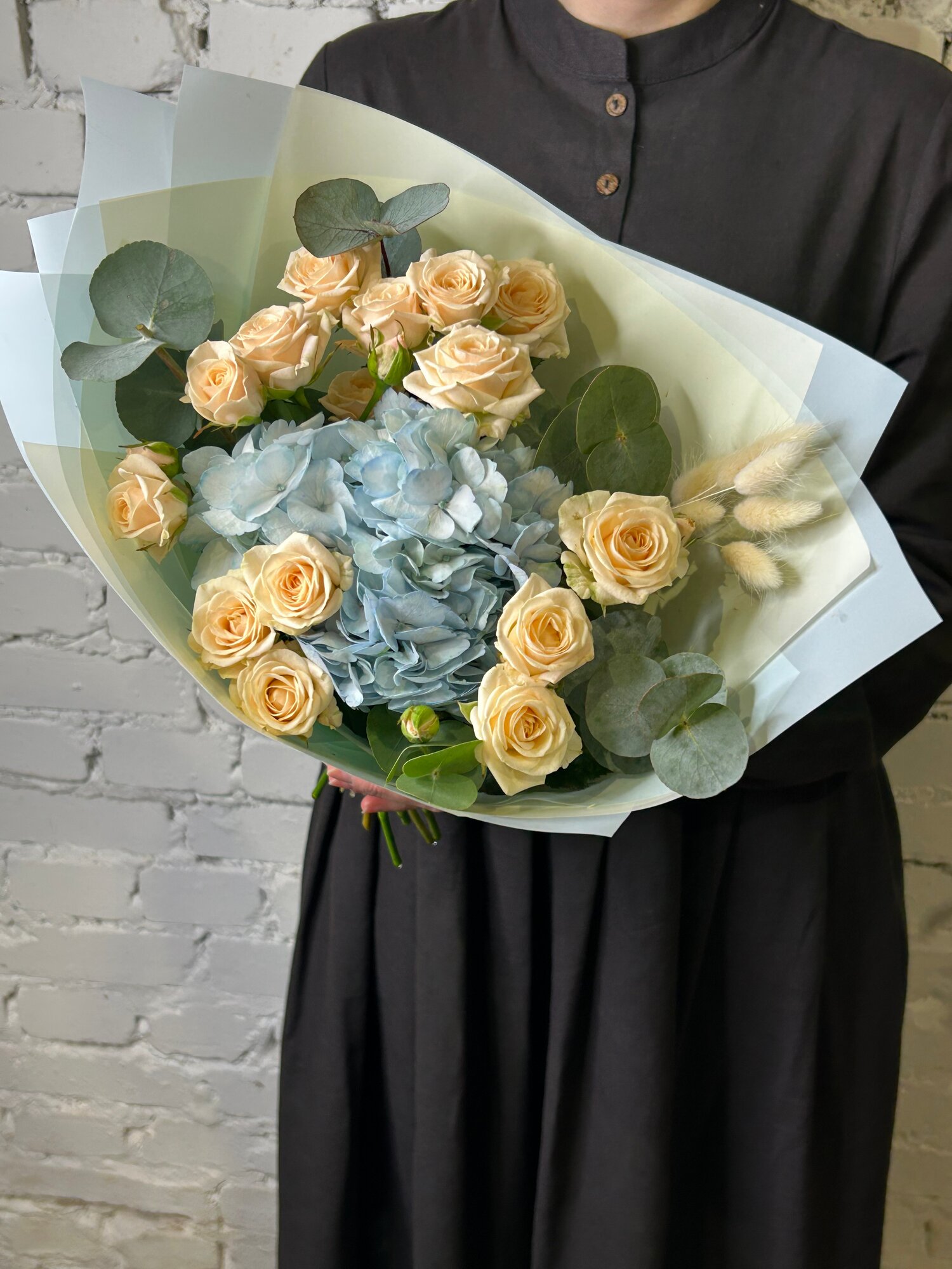 Букет свежесрезанных цветов из гортензии, кустовых роз и ароматного эвкалипта в дизайнерской упаковки