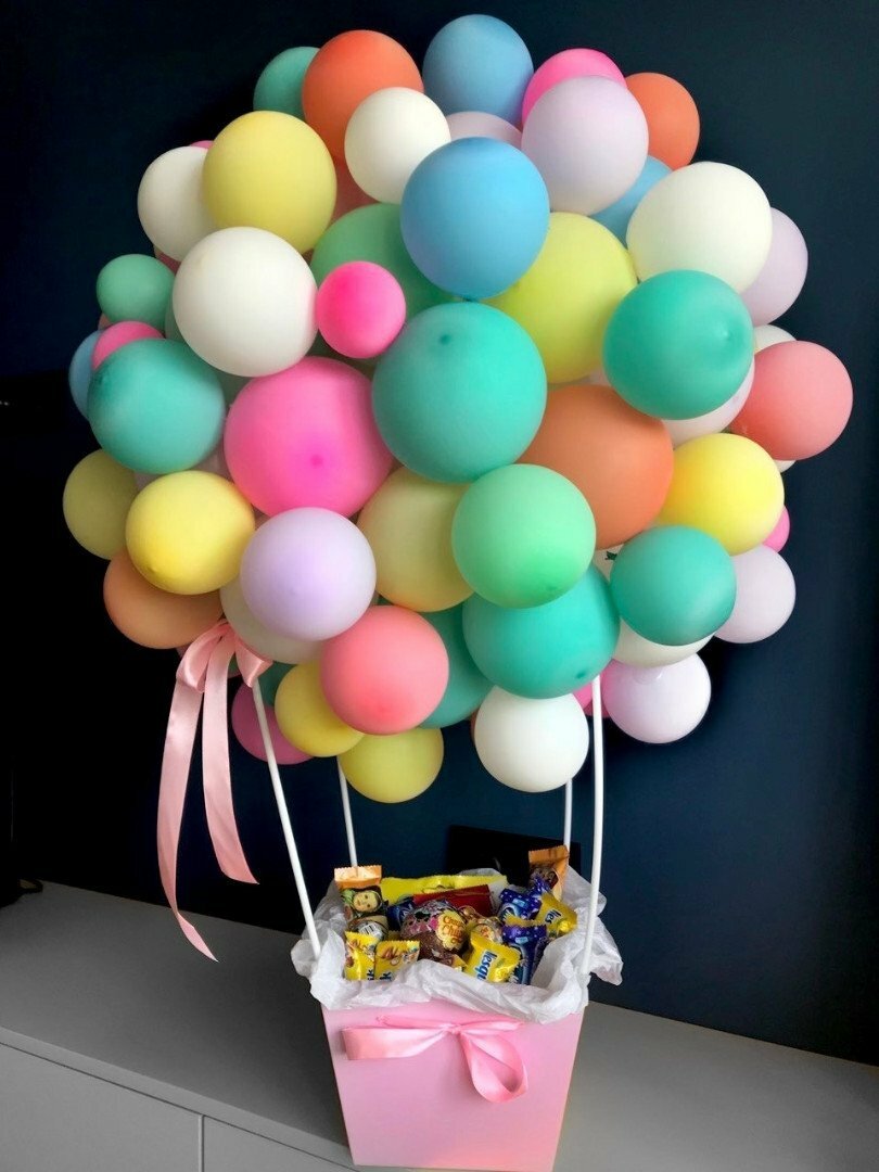 Розовая корзина с разноцветными воздушными шарами на Пасху