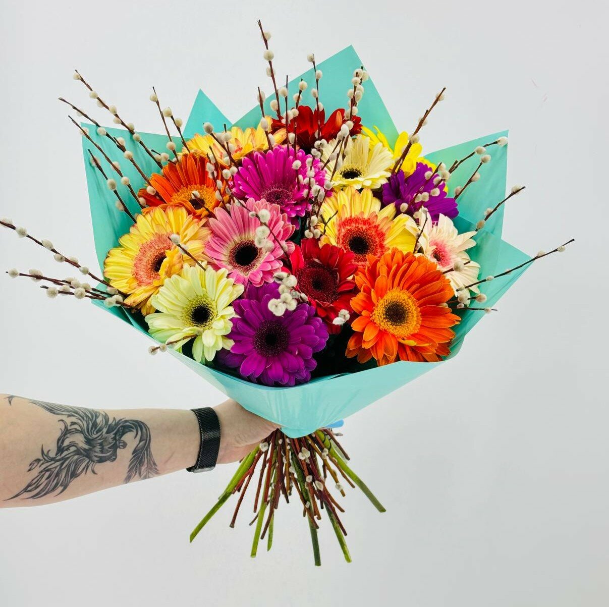 Большой пышный букет из 15 разноцветных гербер с веточками живой вербы. Пасхальный букет