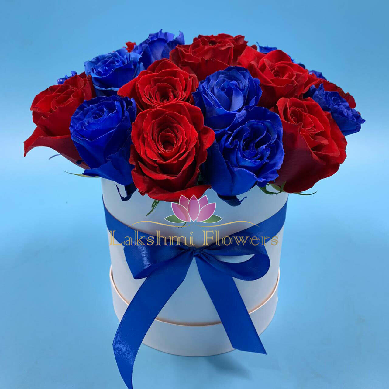 25 синих и красных роз в белой шляпной коробке с синим бантом