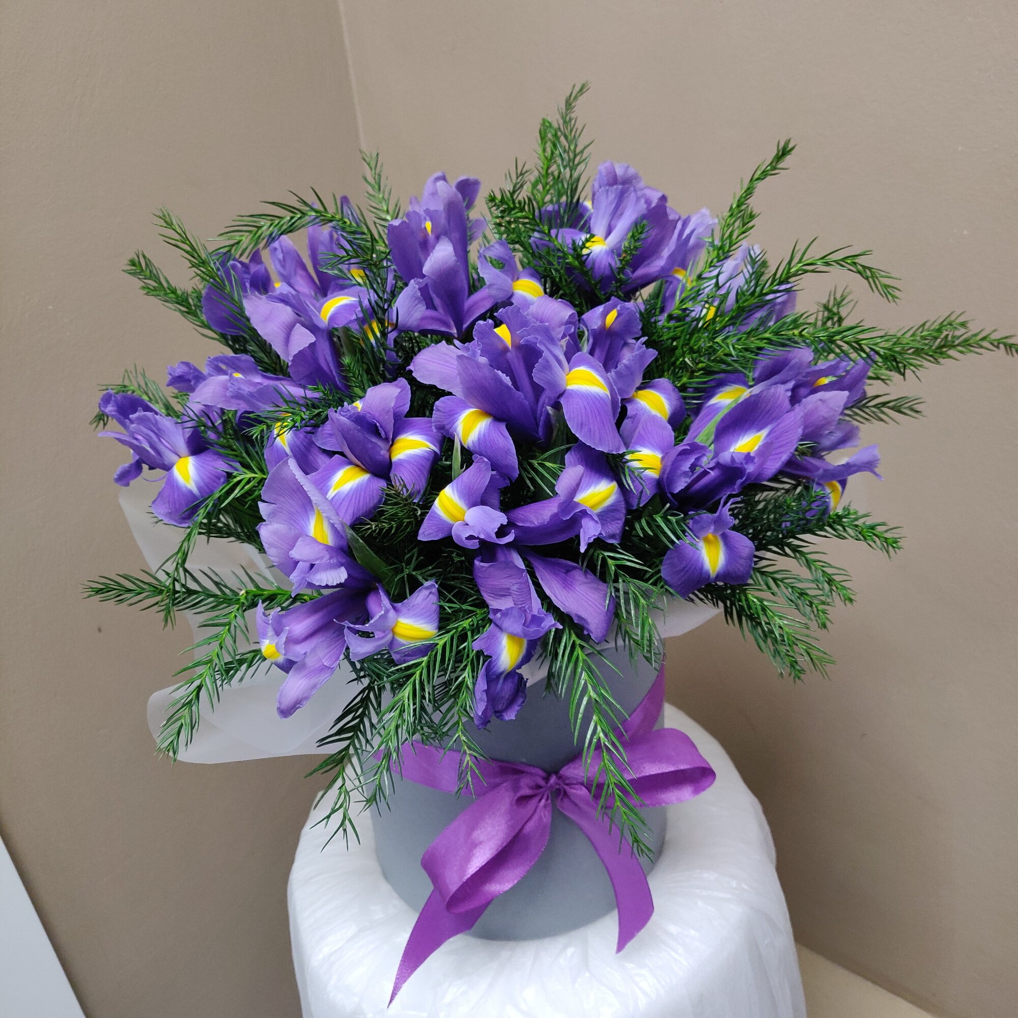 Невероятно красивая, яркая композициия фермерских ирисов и хвои в подарочной коробке.