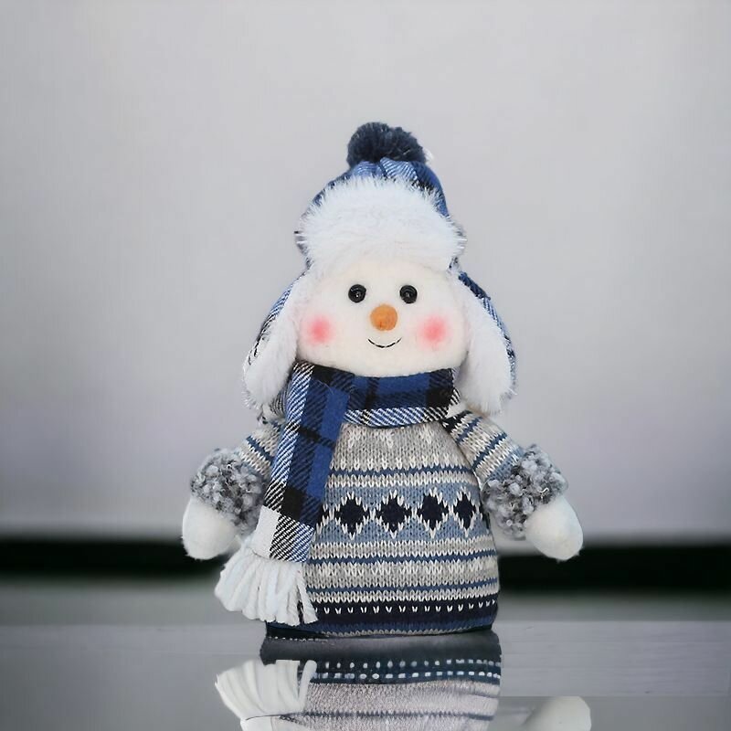 Красивая и милая вязаная игрушка-снеговик под рождественской елкой