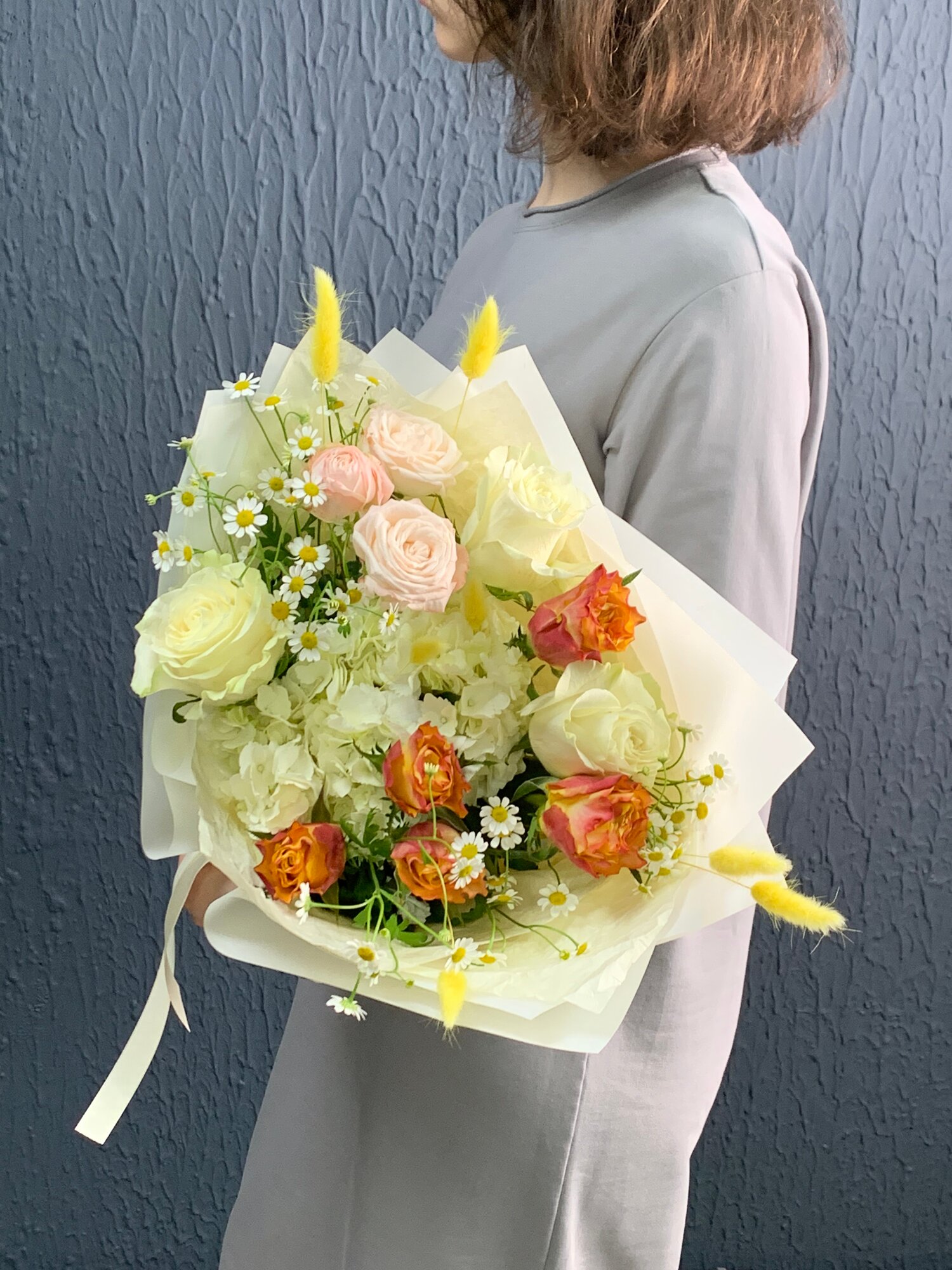 Букет живых цветов из гортензии, розы, кустовые розы и ромашки кустовые в дизайнерской упаковке.