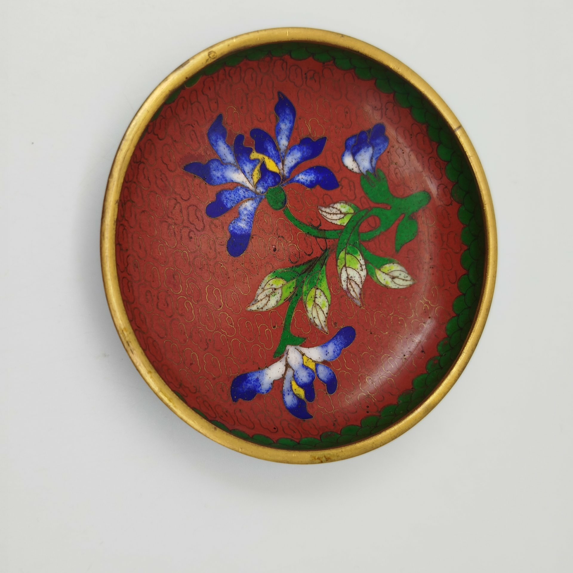 Розетка с изображением синих цветов на красном облачном фоне