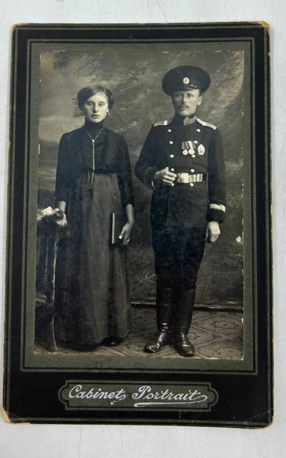Кабинетная фотография неизвестного мужчины в офицерской форме нижних чинов с наградами и девушки Россия 1900е годы.