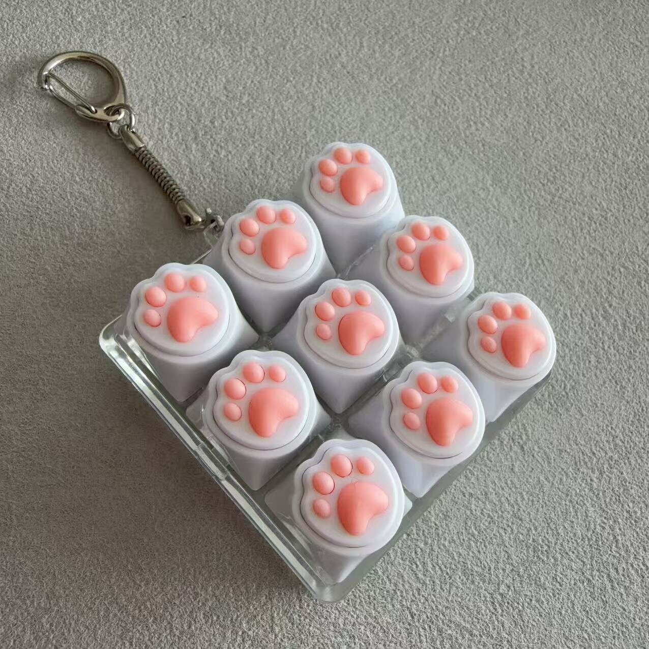 Многоцветная 9-кнопочная антистрессовая силиконовая игрушка-кнопка в виде кошачьей лапки с мультяшным рисунком для тестирования клавиатуры.