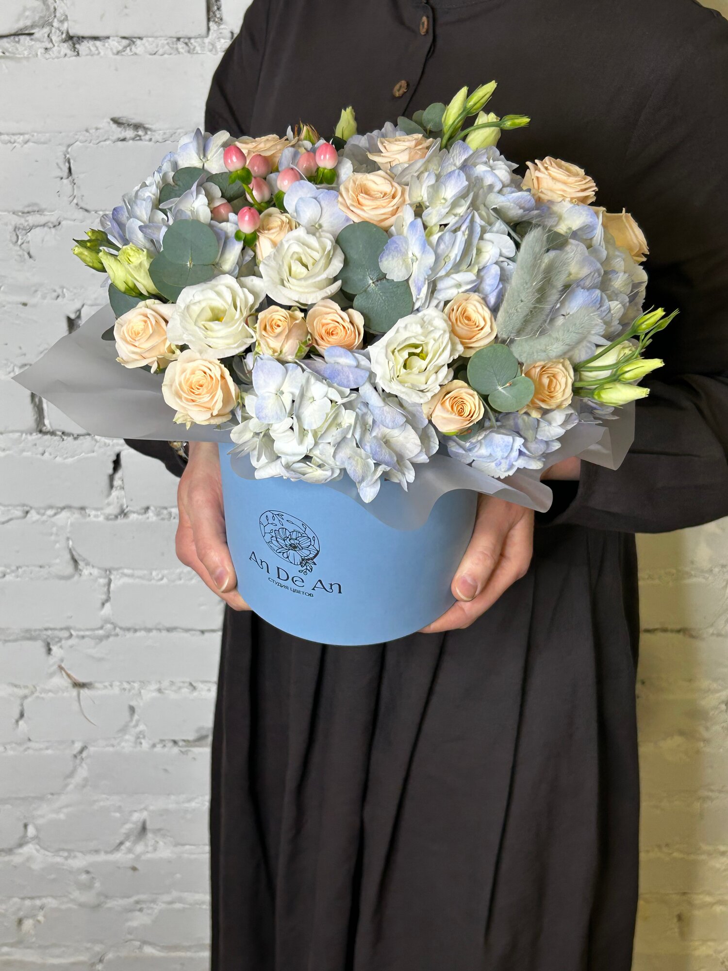 Коробка свежесрезанных цветов из кустовых роз, гортензии, эустомы, и ароматного эвкалипта.