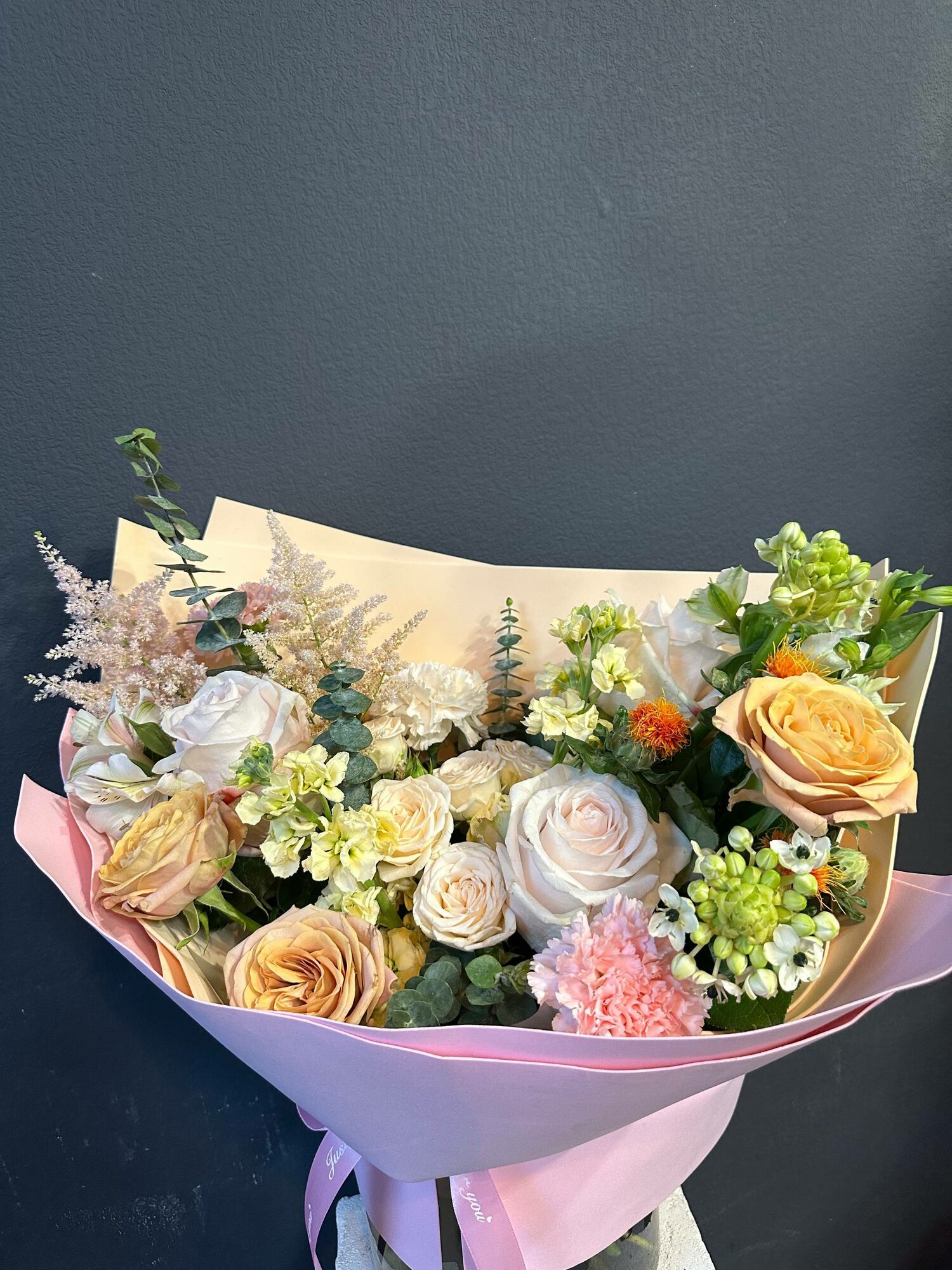 Яркий букет с кустовыми розами, альстромерией, маттиолой, орнитогалумом, астильбой и эвкалиптом в упаковке