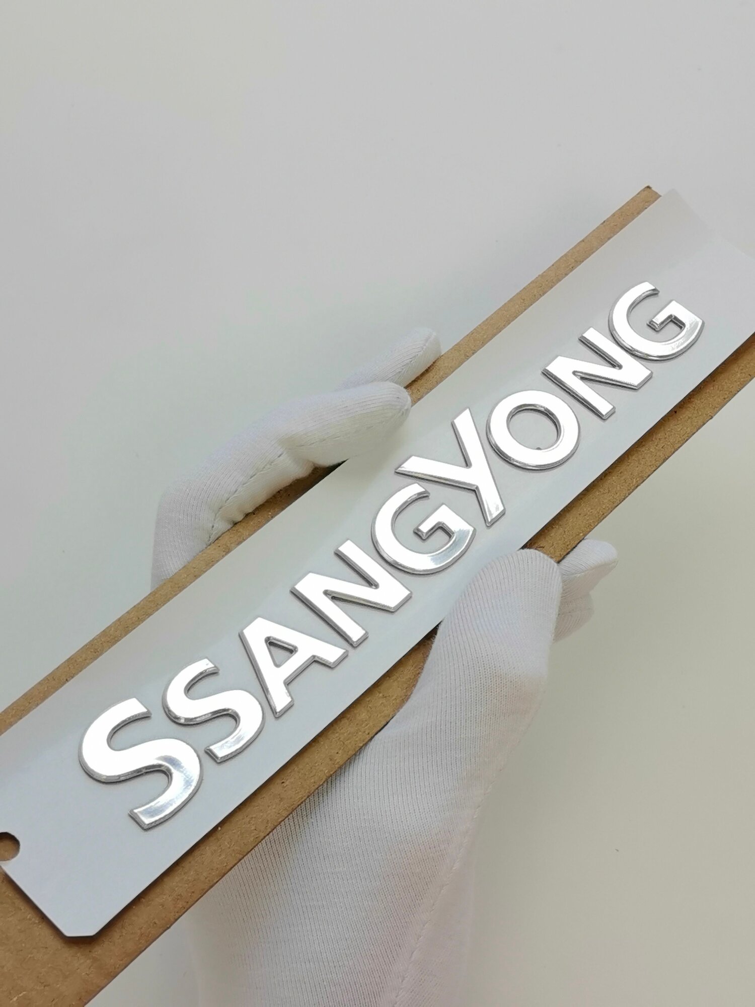 Эмблема SsangYong — фирменный шильдик 16,5×2,2 см на двустороннем скотче, для замены утерянной или же выцветшей