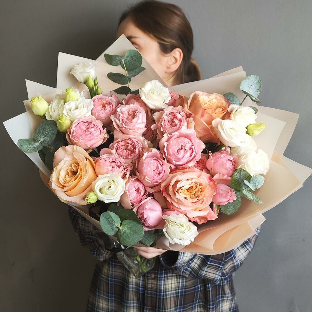 Букет живых цветов от Kimbirly Flowers из кустовых и одноголовых пионовидных роз, эустомы и эвкалипта, цвет персиковый
