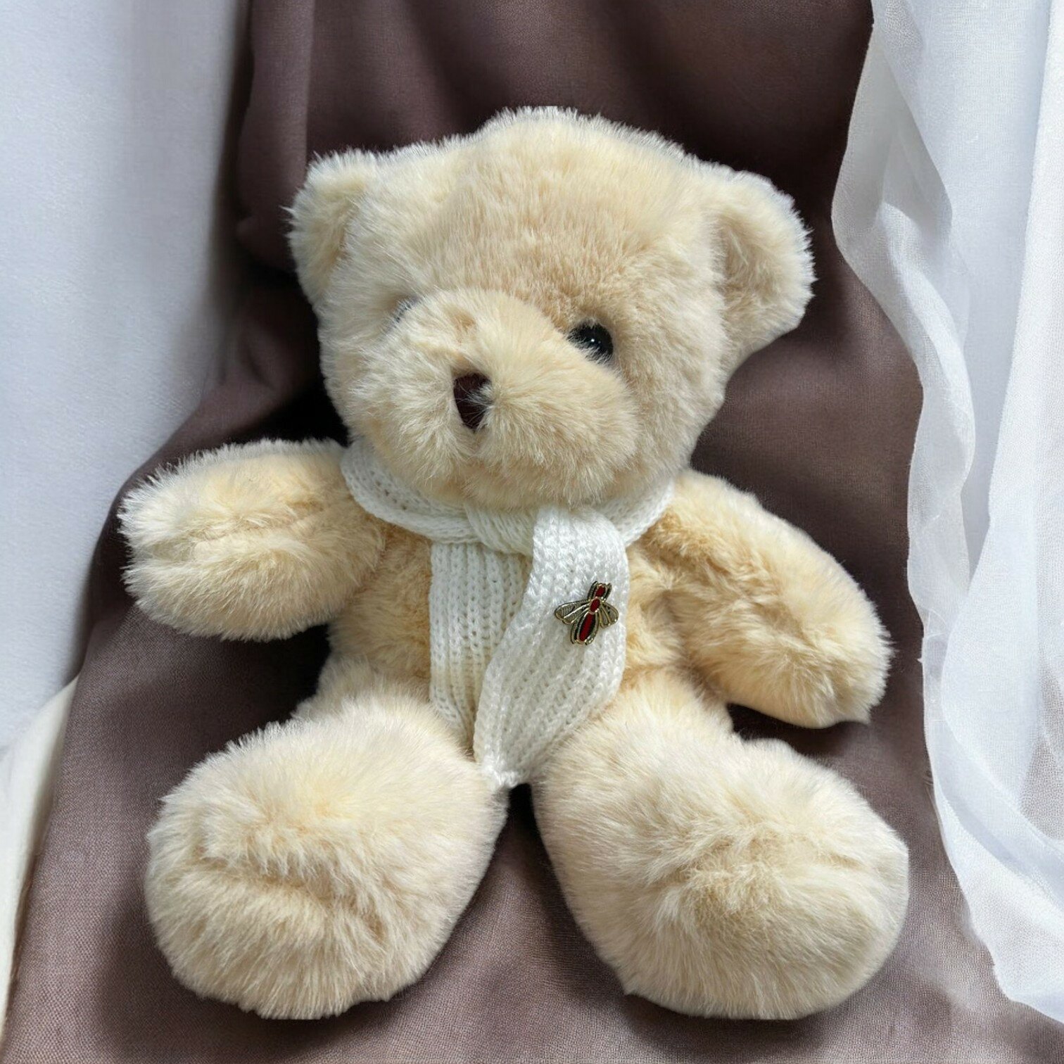 Эксклюзивный бежевый шарф дополняет популярного плюшевого медведя