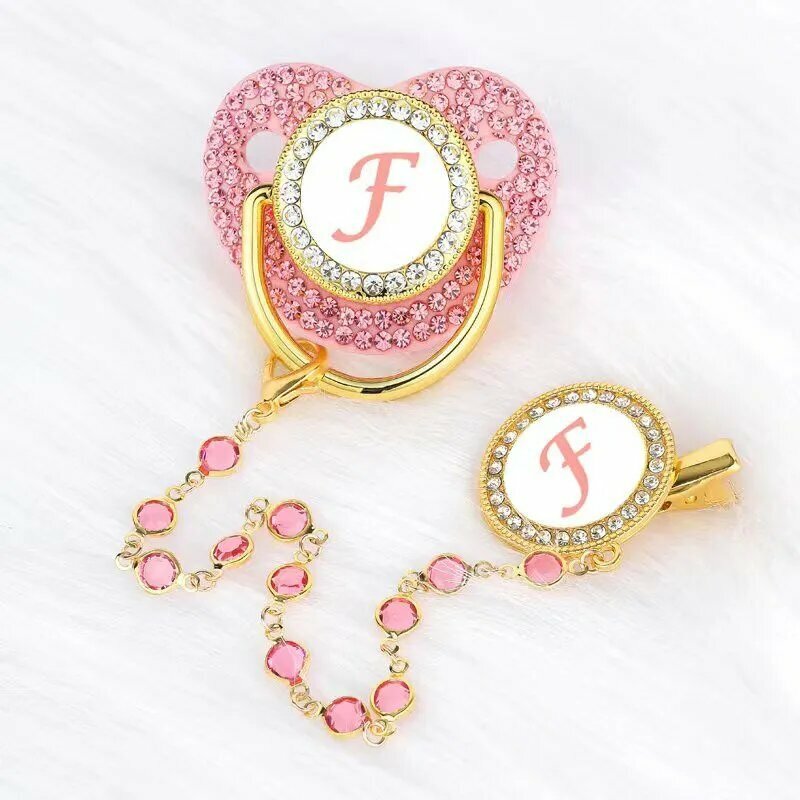 Детский сосок розового цвета с бриллиантами, с бусинами и цепочкой.