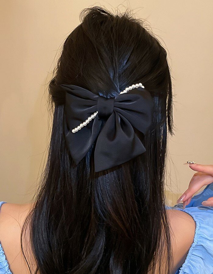 Заколка для волос, декорирована бантом черного цвета, а так же жемчугом