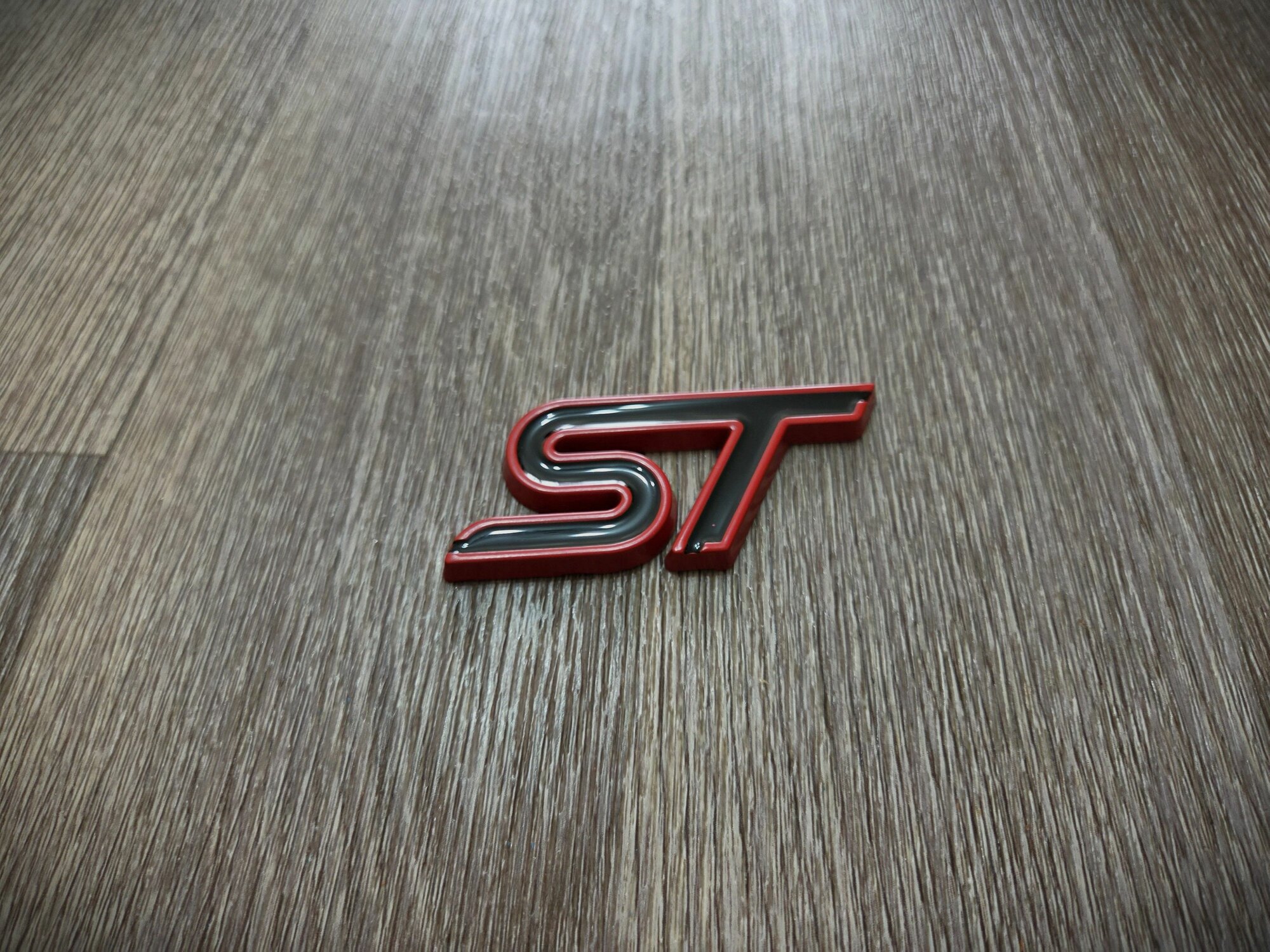 Шильдик ST черный с красной окантовкой задний на крышку багажника на Форд Фокус 2, Форд Фокус ST, Форд Фиеста