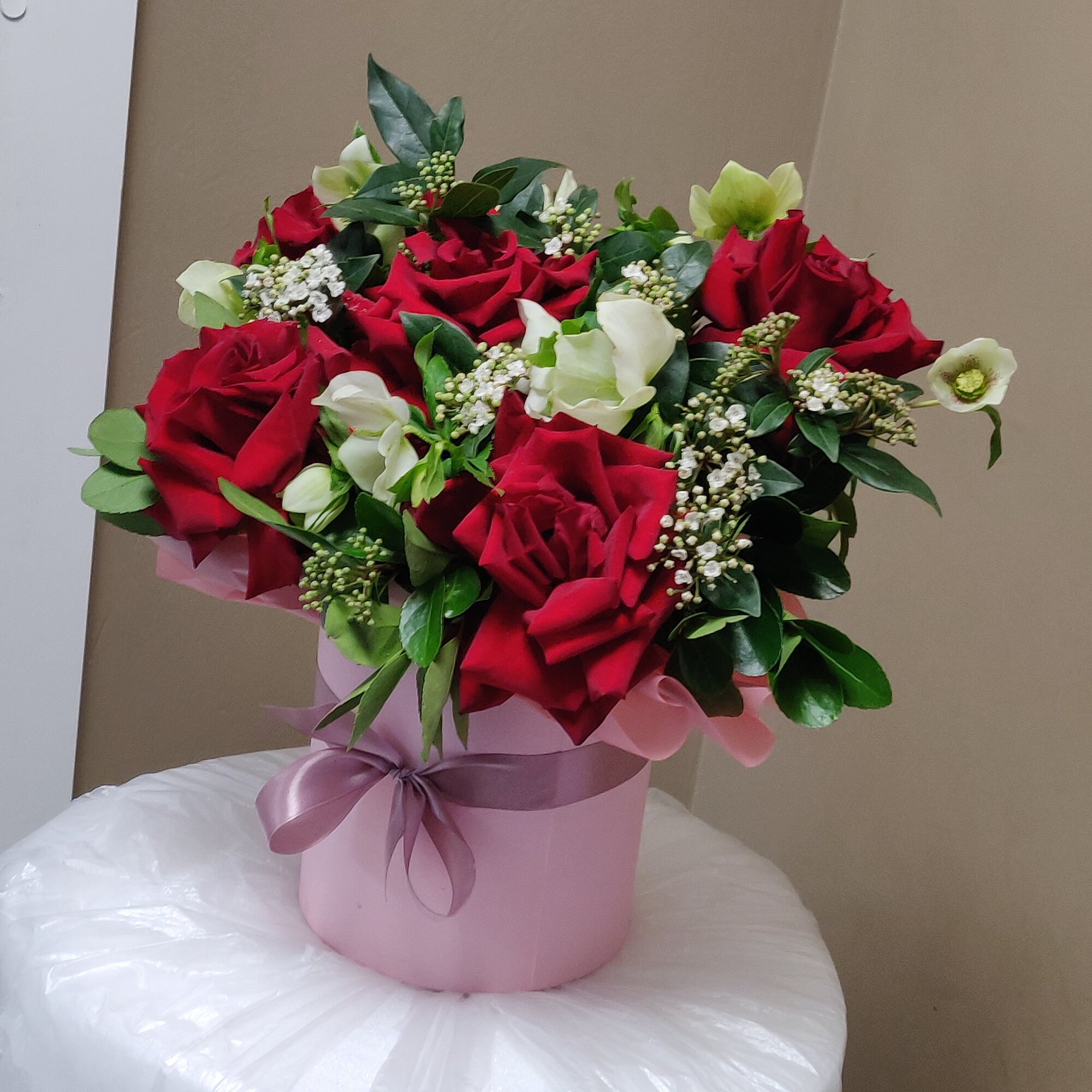 Изысканная композиция вишневых роз, цветущих веточек и хелеробуса в подарочной коробке