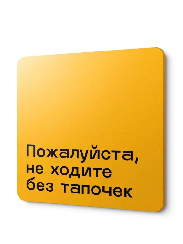 Квадратная табличка жёлтого цвета с чёрным текстом "Пожалуйста, не ходите без тапочек"