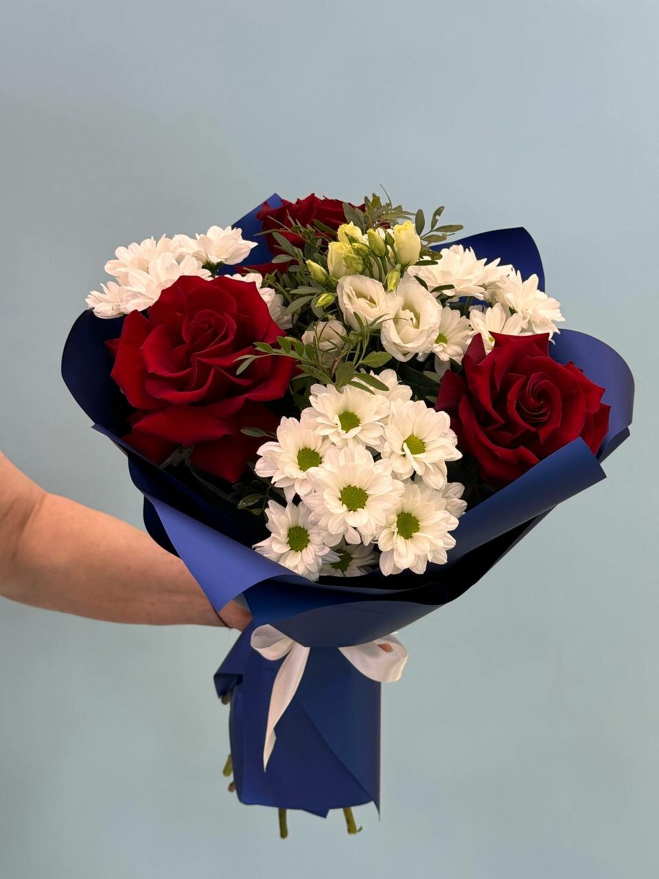 Букет трио с бордовыми фактурными розами и кустовой хризантемы в виде ромашек и нежной эустомой.