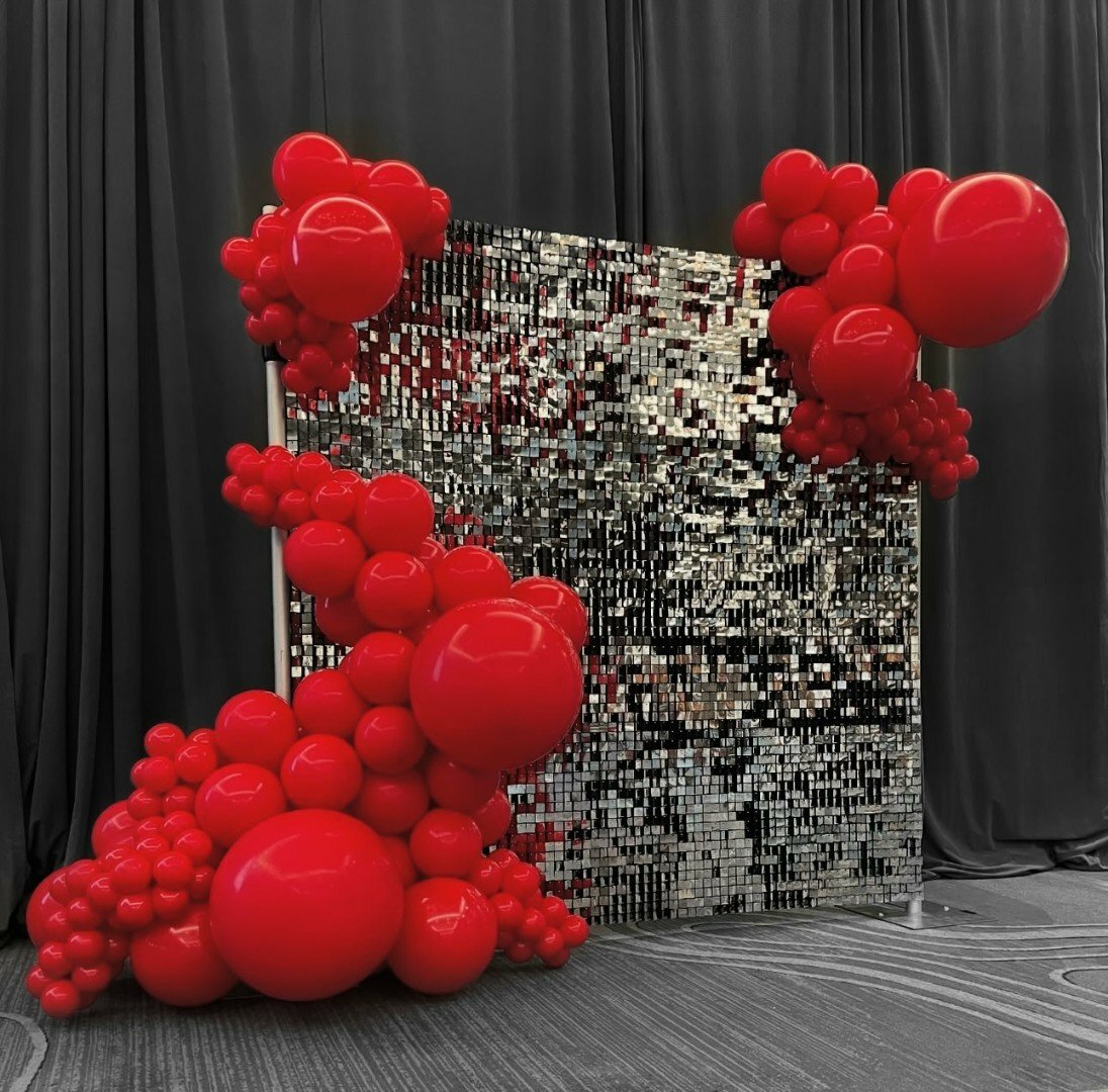 Вау-фотозона с красными шарами и серебрянным большим баннером